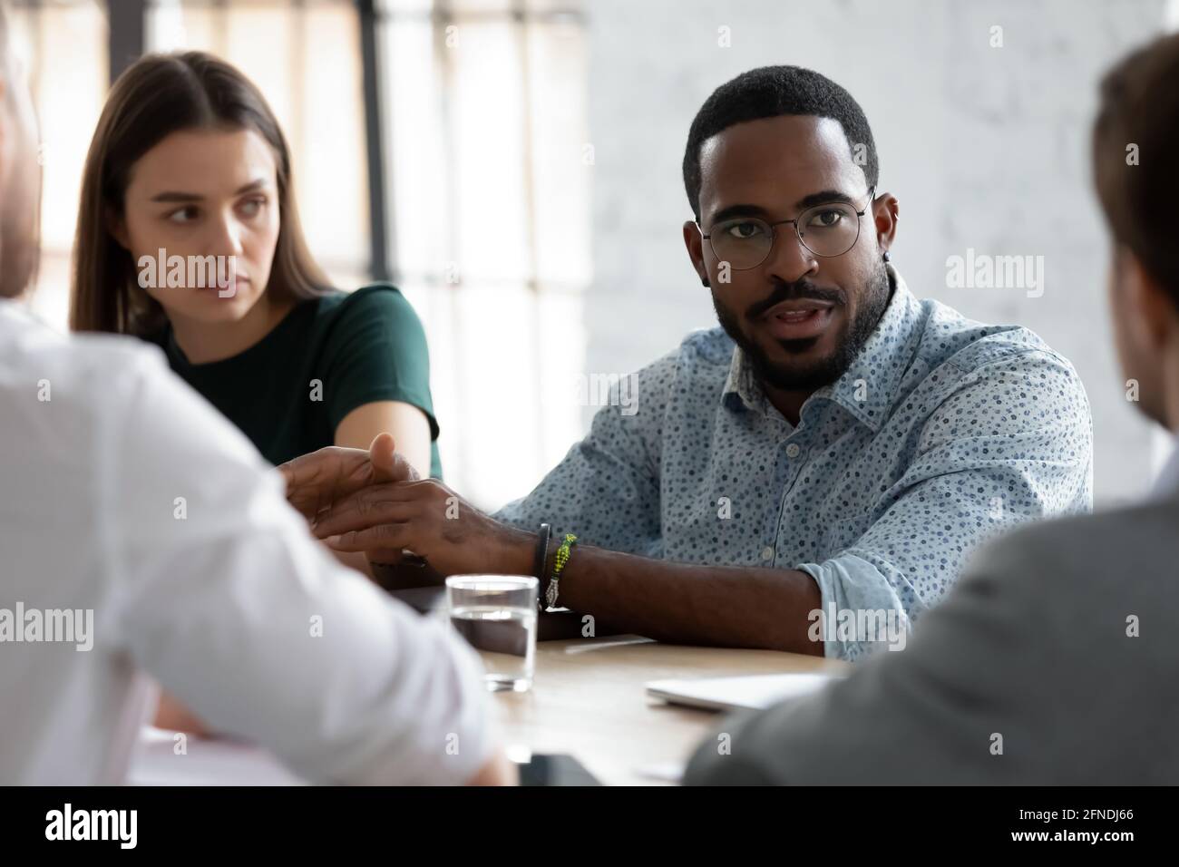 Focused African American coach teaching group of interns Stock Photo ...