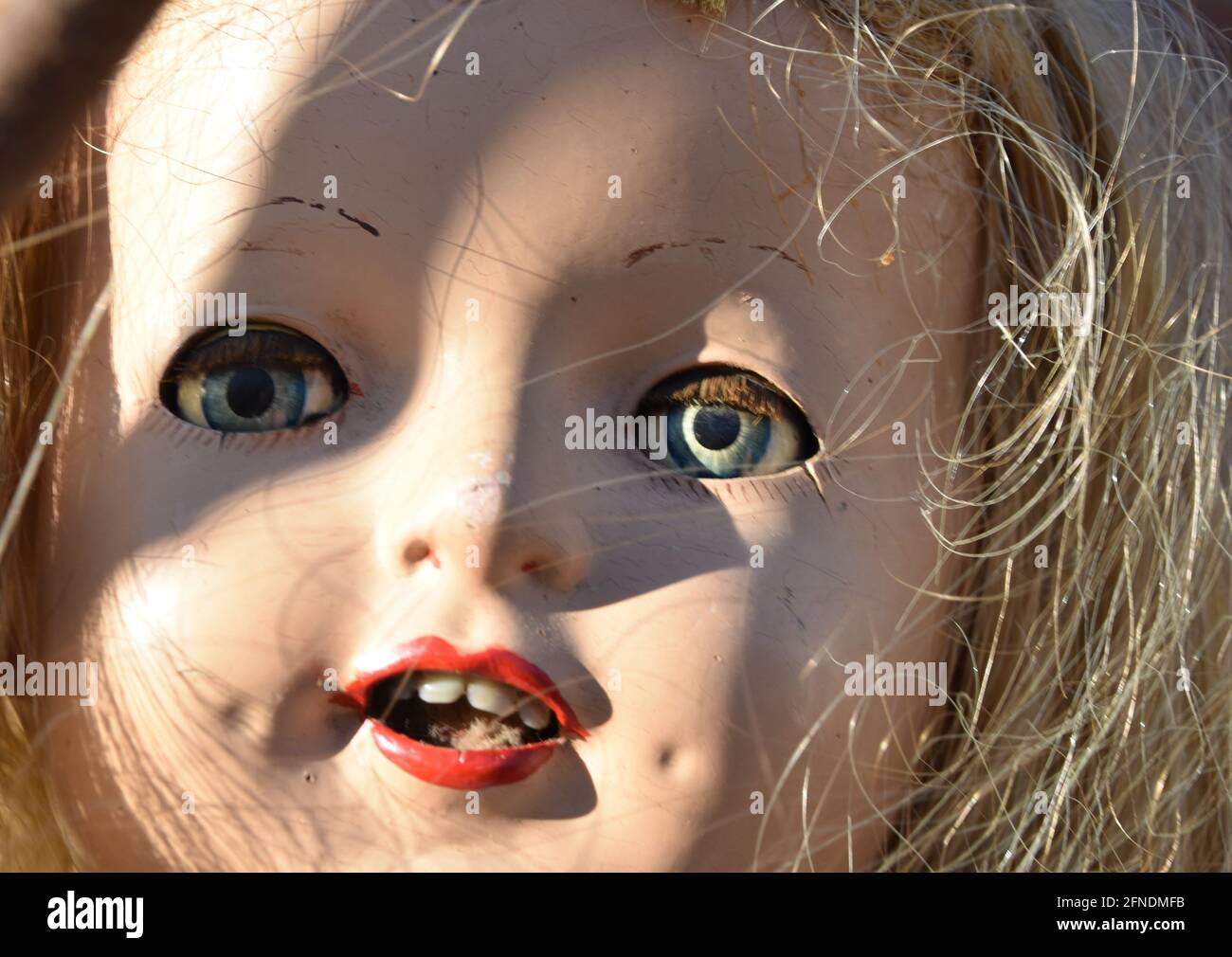 A closeup of a creepy old doll face with disheveled hair Stock Photo ...
