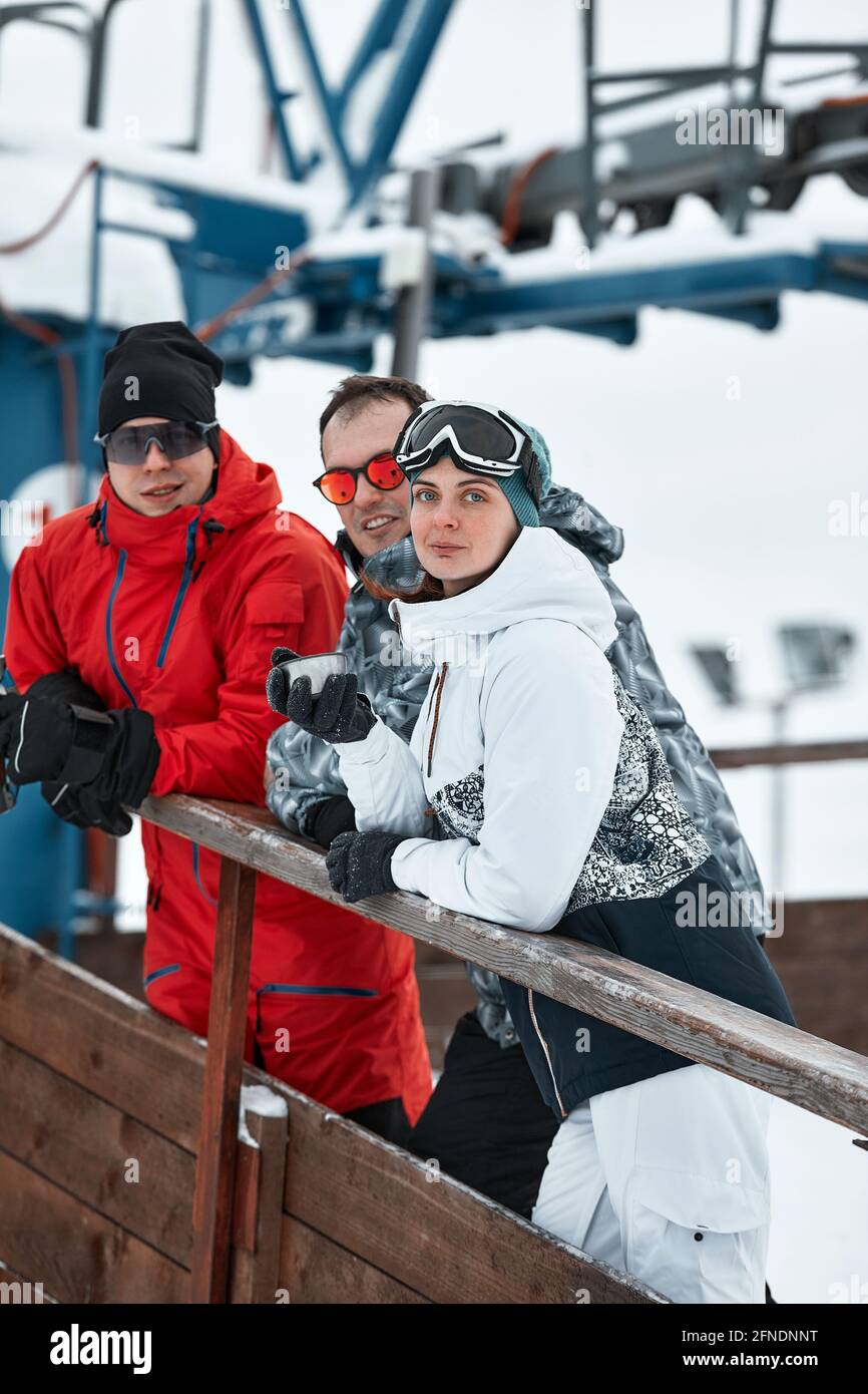 group of skiers friends on the mountain are resting and drinking coffee ...