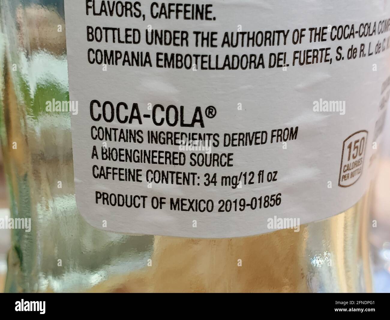 Close-up of a label on a Coca-Cola bottle reading 'Contains ingredients ...