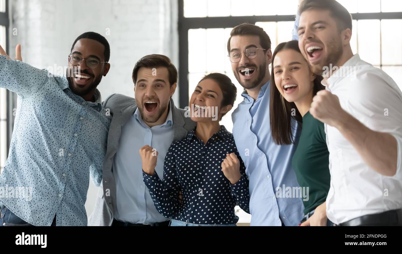 Multiethnic team of excited employees celebrating corporate achievement ...