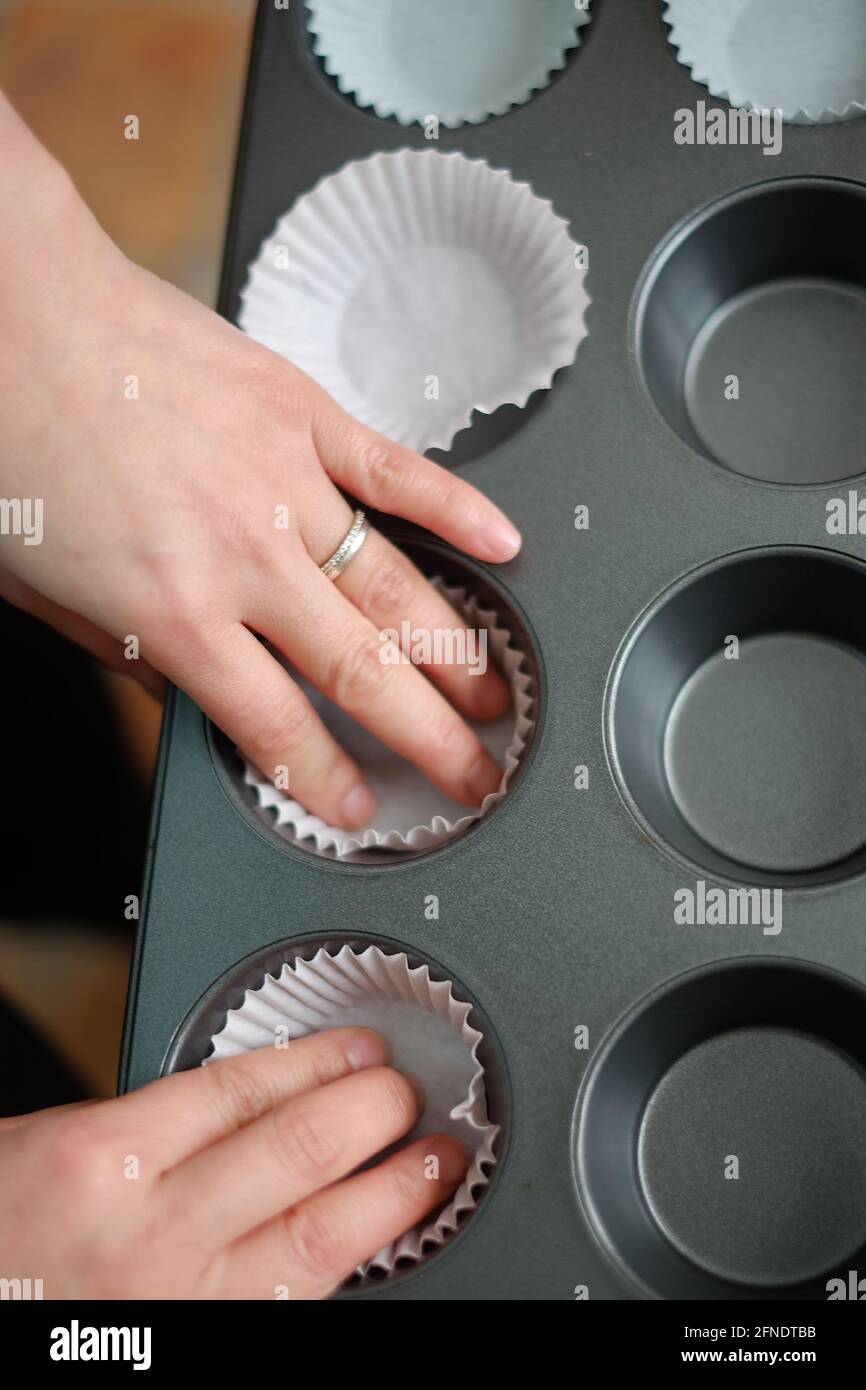 Asian Filipino woman setting cupcake paper cups at home in Ottawa ...