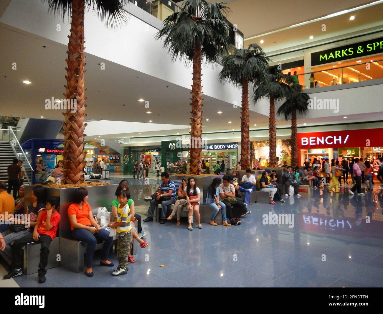 Shoppers sit and walk around Mall of Asia, Metro Manila, Philippines ...