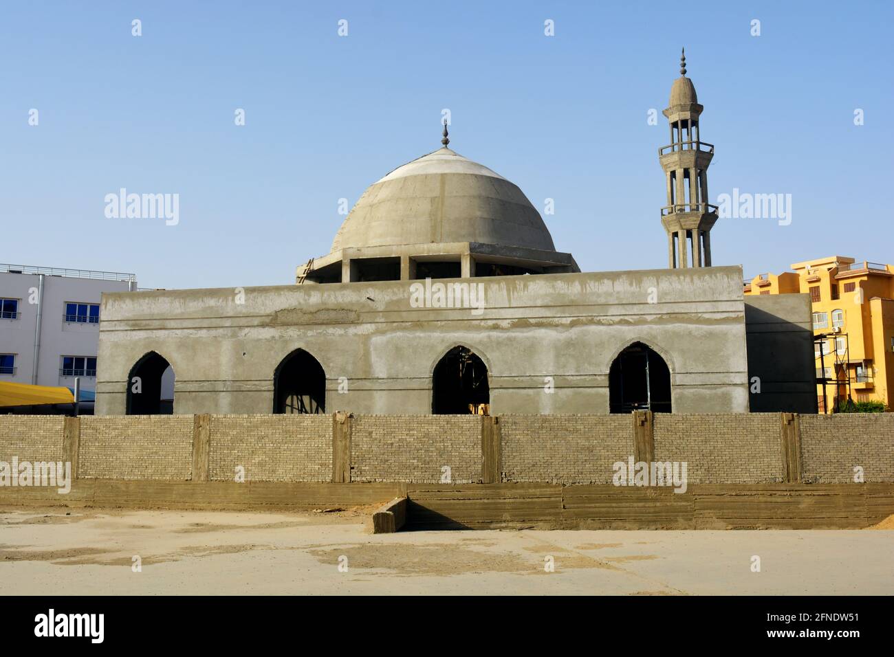 A new mosque under construction against the sunny blue sky, building a ...