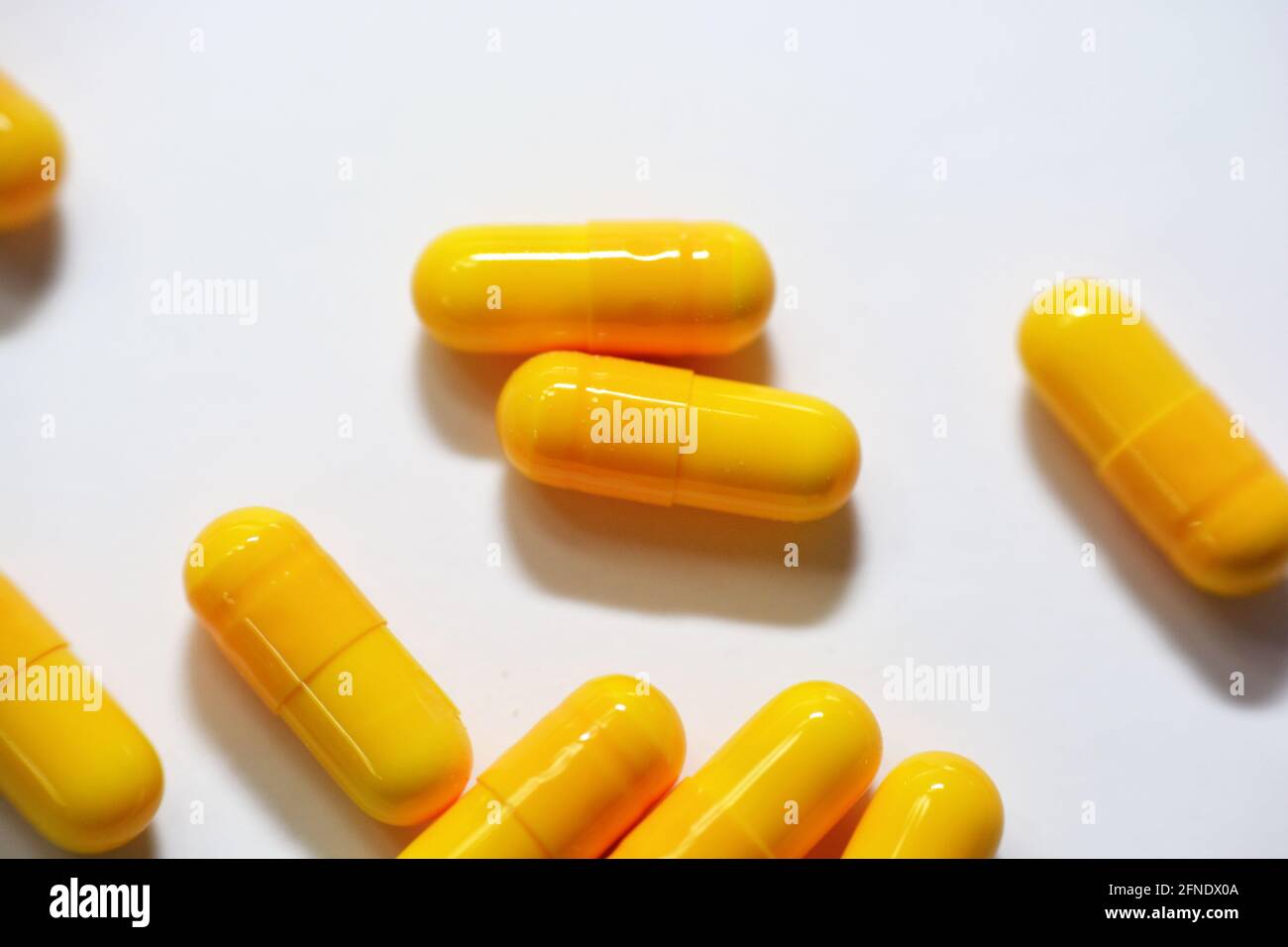 a close up of yellow pharmaceutical medicine pills capsules isolated on ...