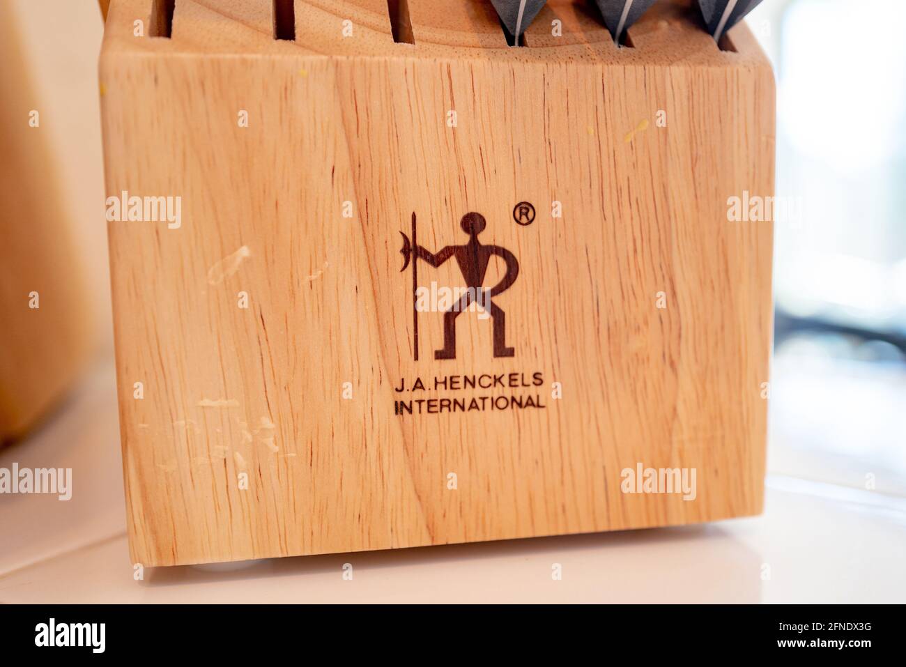 Close-up of a wooden knife stand, with a Zwilling J A Henckels ...