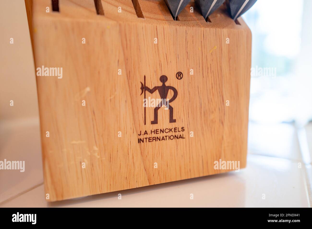 Close-up of a wooden knife block, with a Zwilling J A Henckels logo ...