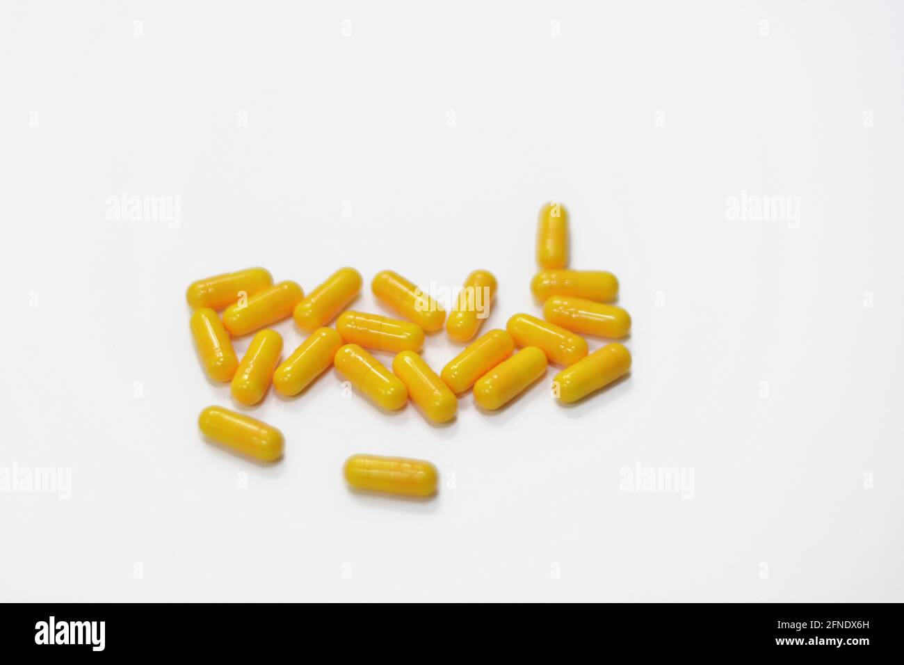a close up of yellow pharmaceutical medicine pills capsules isolated on ...