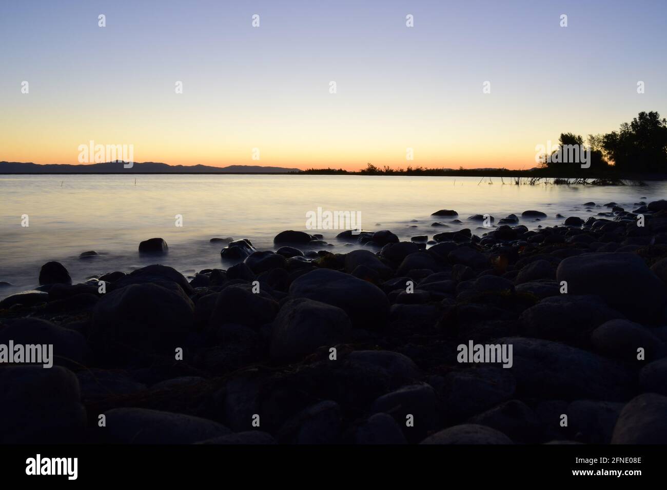 Sunset on the lakeshore Stock Photo - Alamy