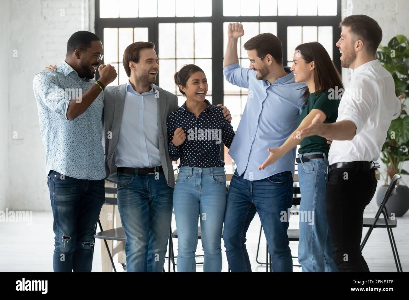 Excited motivated colleagues shouting for joy and celebrating team ...