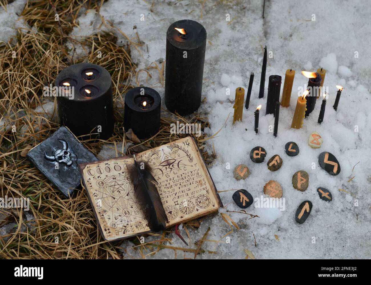 Witch ritual of black magic with open book of spell, runes and candles ...