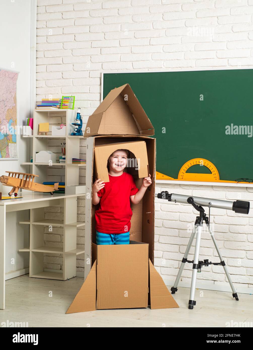 Child boy in an astronaut costume with toy rocket playing and dreaming ...