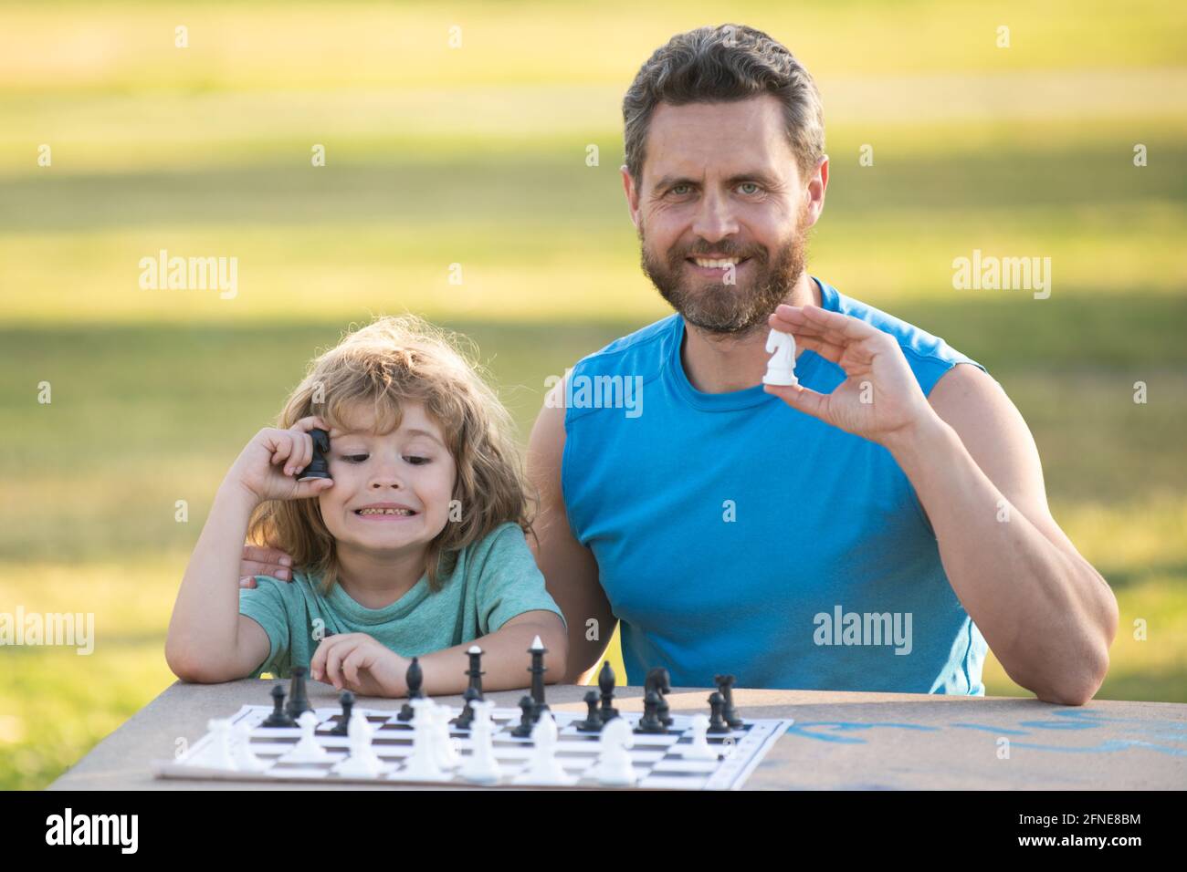 Father play chess with son. Family outside game. Kid boy play chess ...