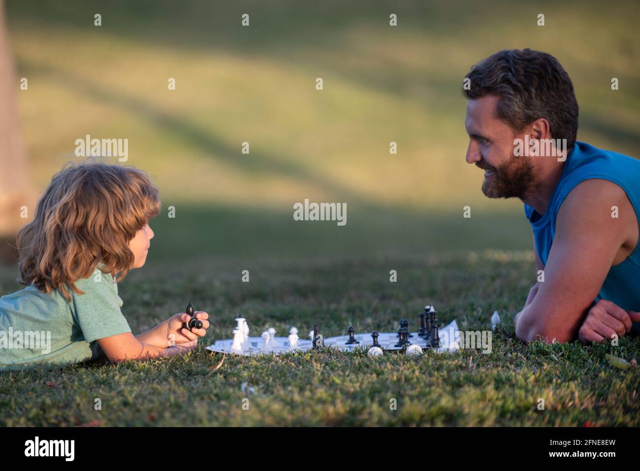 Father play chess with child son. Family outside game Stock Photo - Alamy