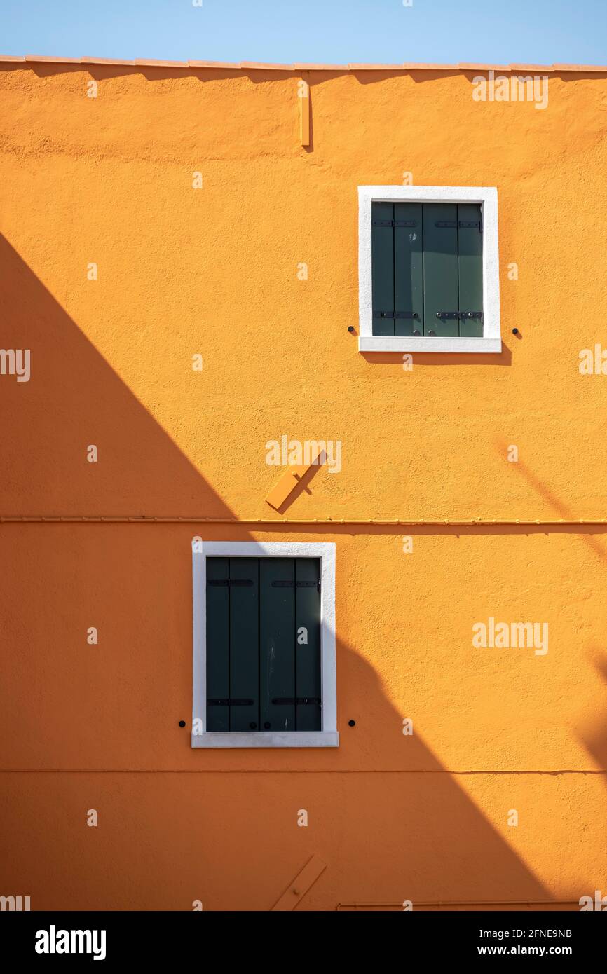 Orange house wall with windows, closed shutters, colorful house wall ...