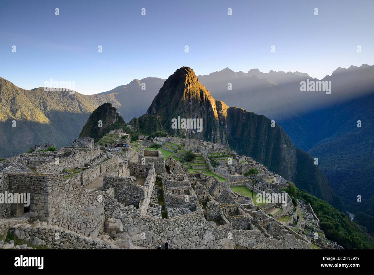 Inca ruined city with Mount Huayna Picchu with first rays of sun, Machu ...