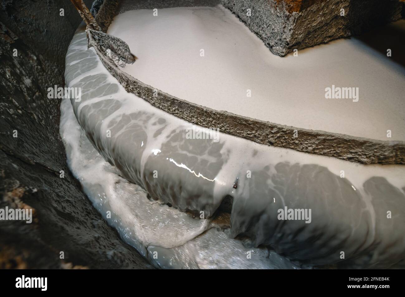 Flotation machine. A stream of gray, dirty liquid flows down from the ...