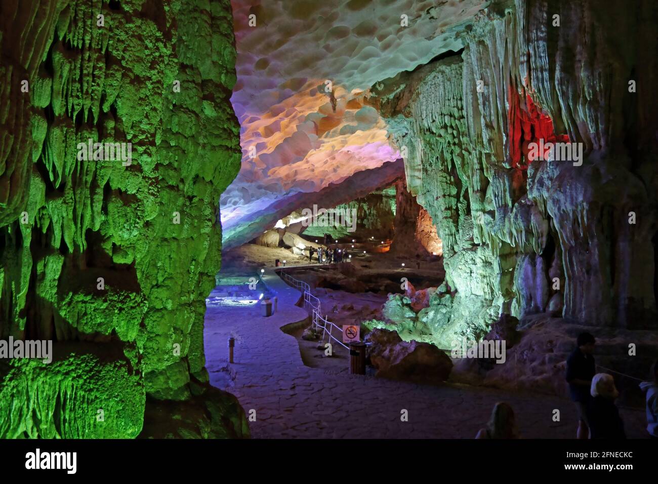 Visitors in large limestone karst cave with stalactite and stalagmite ...