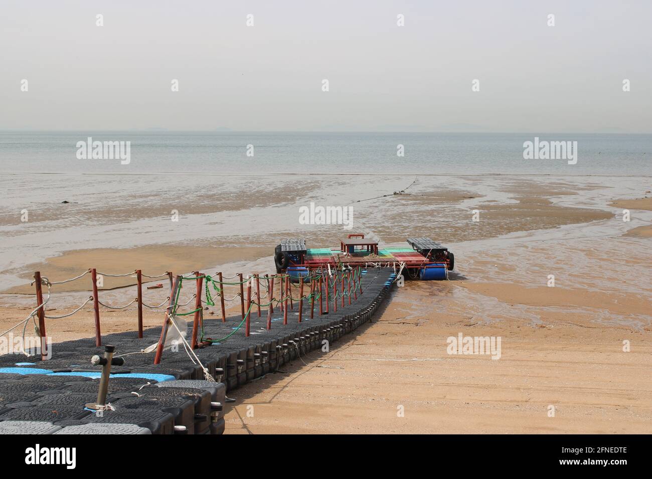 Colorful barge-like floating platform on low-tide beach Stock Photo - Alamy