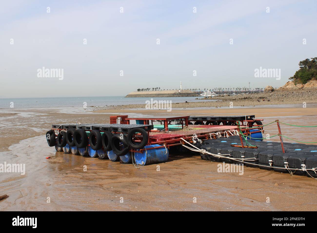 Colorful barge-like floating platform on low-tide beach Stock Photo - Alamy