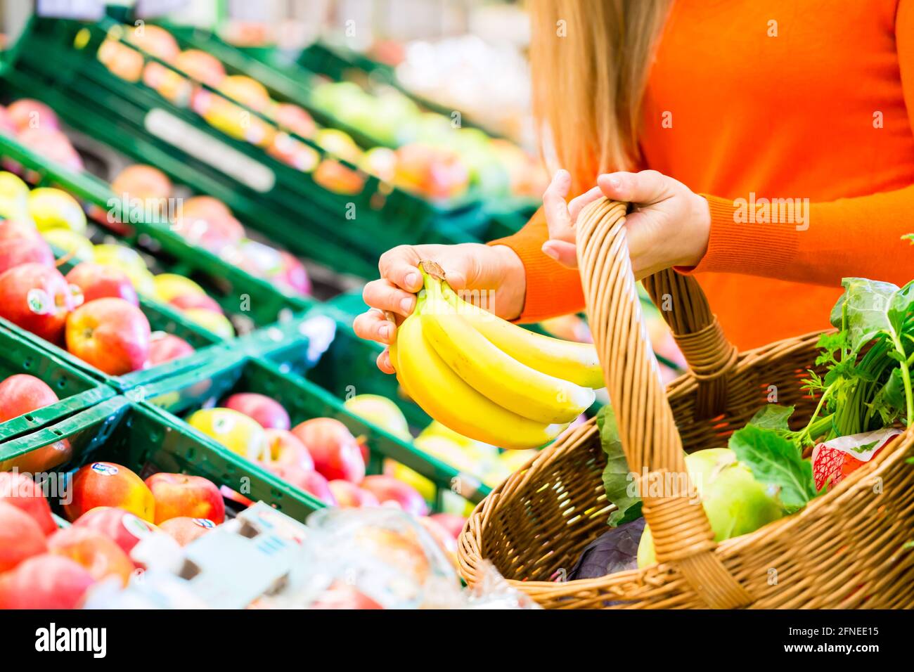 Woman in supermarket at the fruit shelf shopping for groceries, she is ...