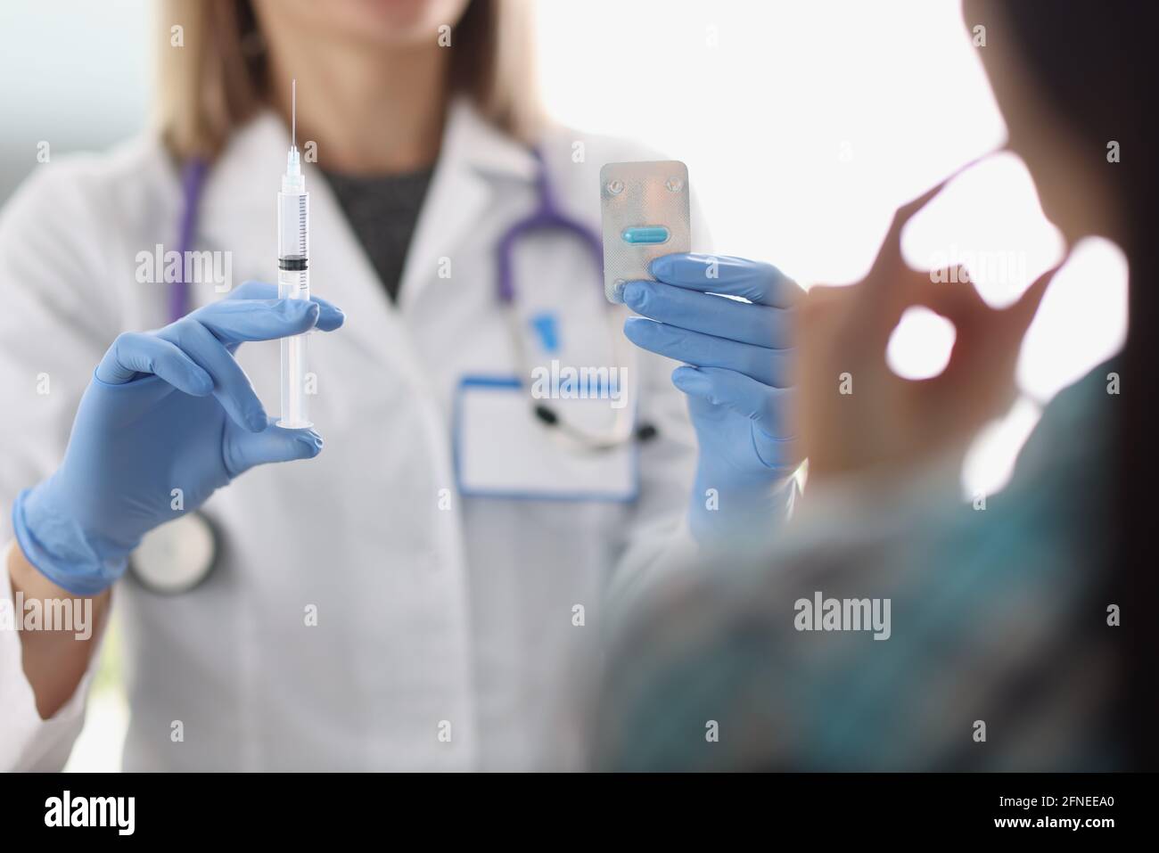 Doctor offers patient choice of an injection or pill Stock Photo - Alamy