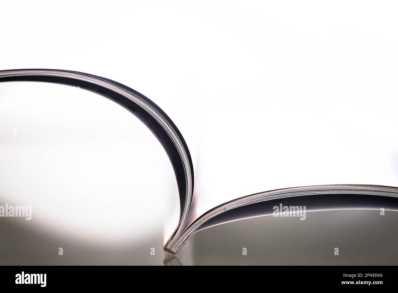 Side view of an open, beautifully curved magazine with narrow depth of ...