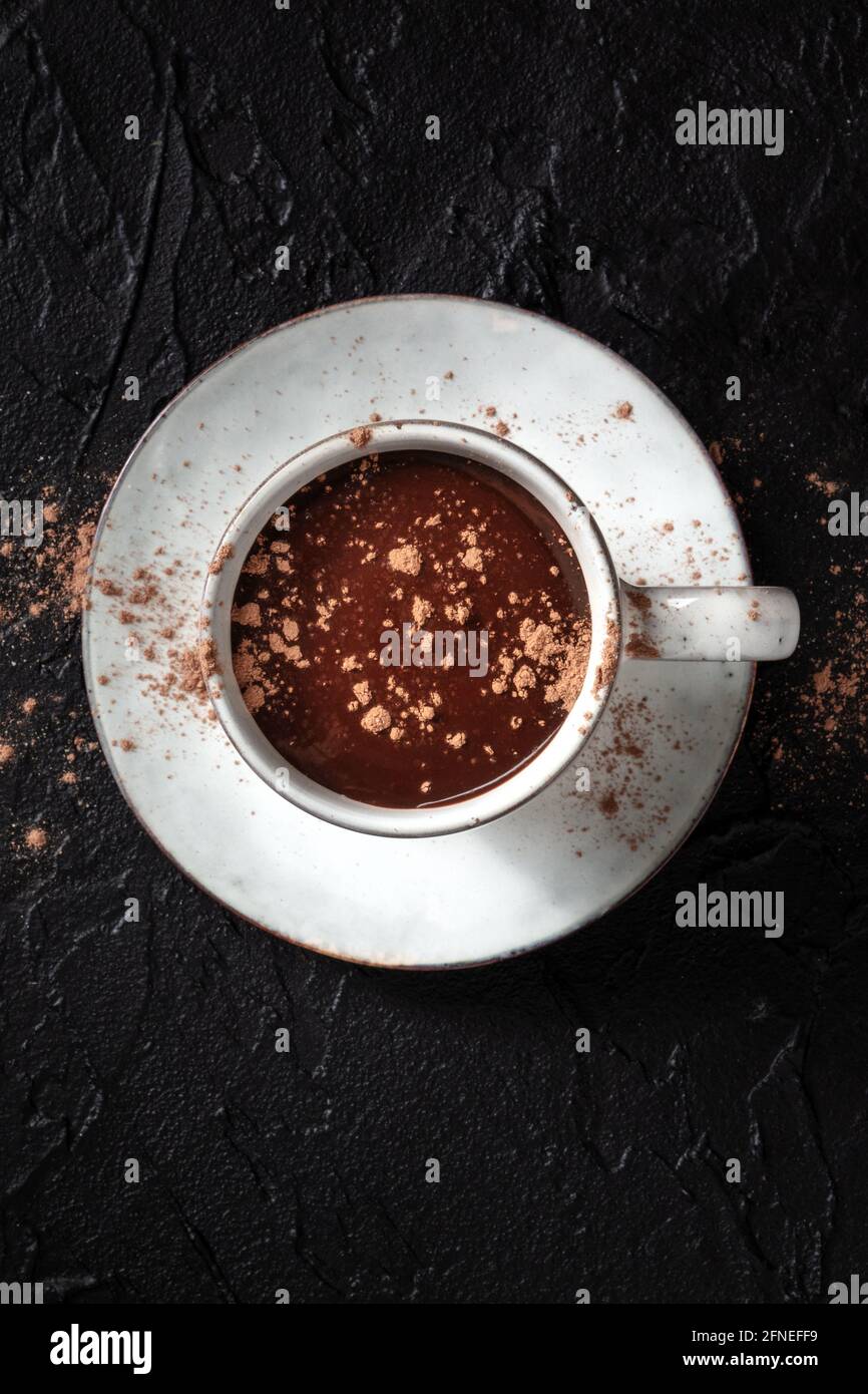 Hot chocolate with chocolate powder, top shot on a black background ...
