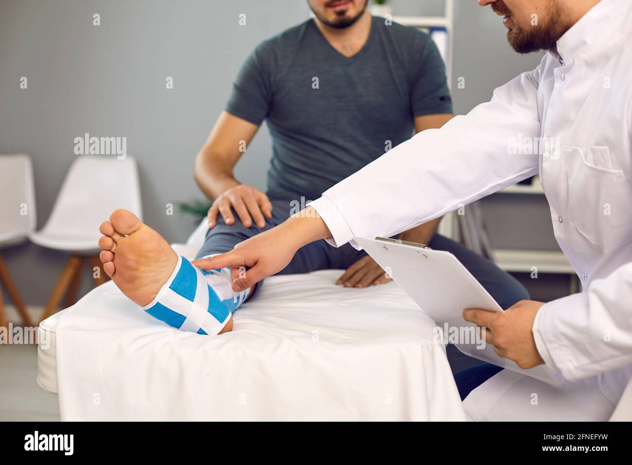 Doctor and patient with broken leg foot ankle in orthopedic care ...