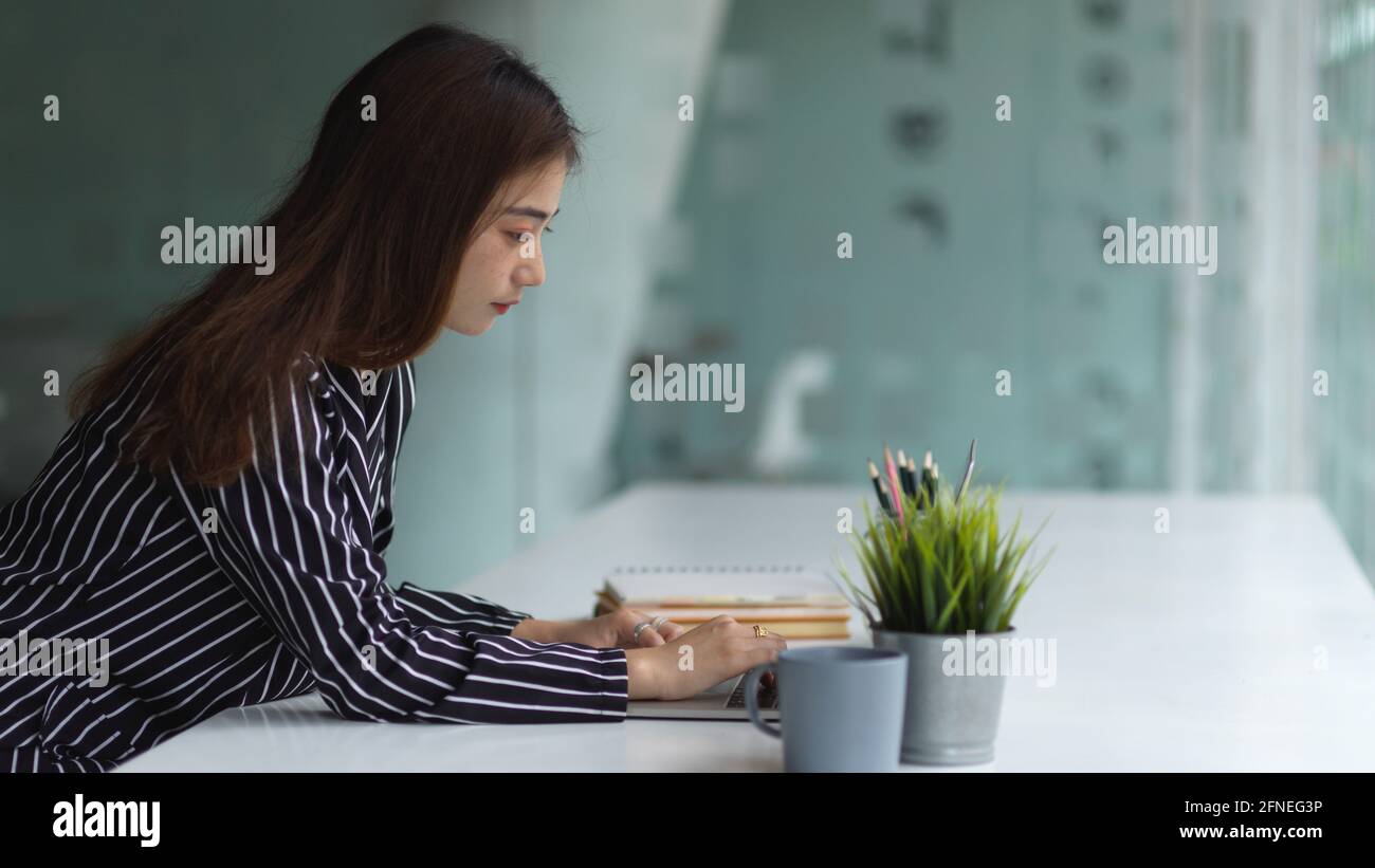 Side view of female working with office supplies on office desk with ...