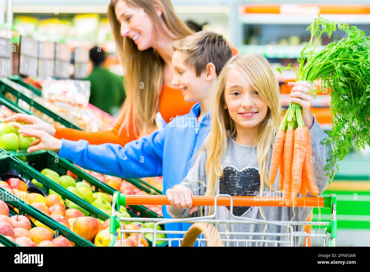 Family selecting fruits and vegetables while grocery shopping in ...
