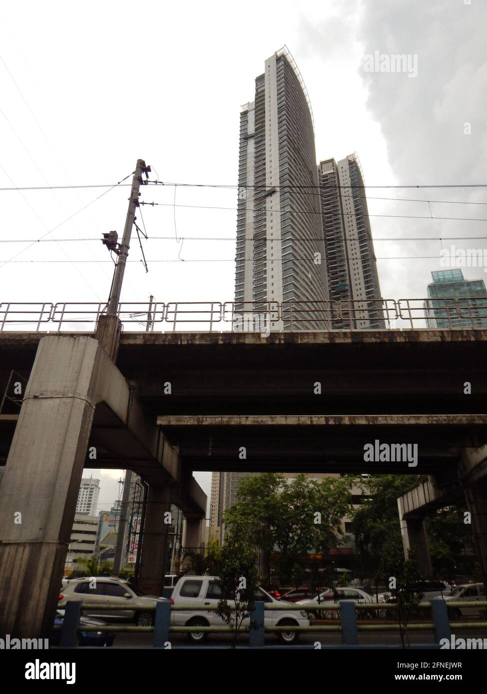 Overpass over traffic and a sky scaper building in Novaliches, Manila ...