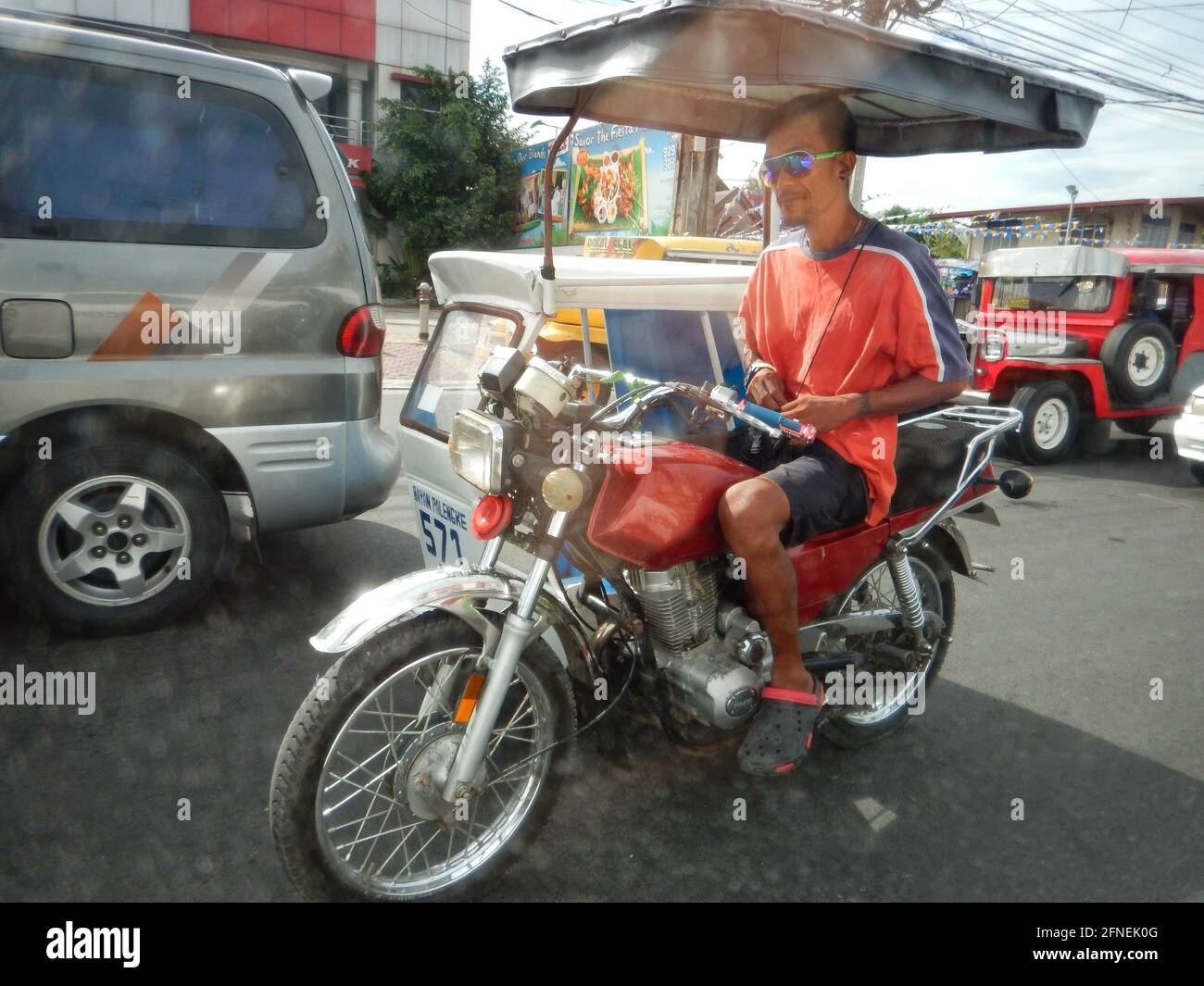 Motorcycle driver smiles as he's driving his sidecar in Novaliches ...