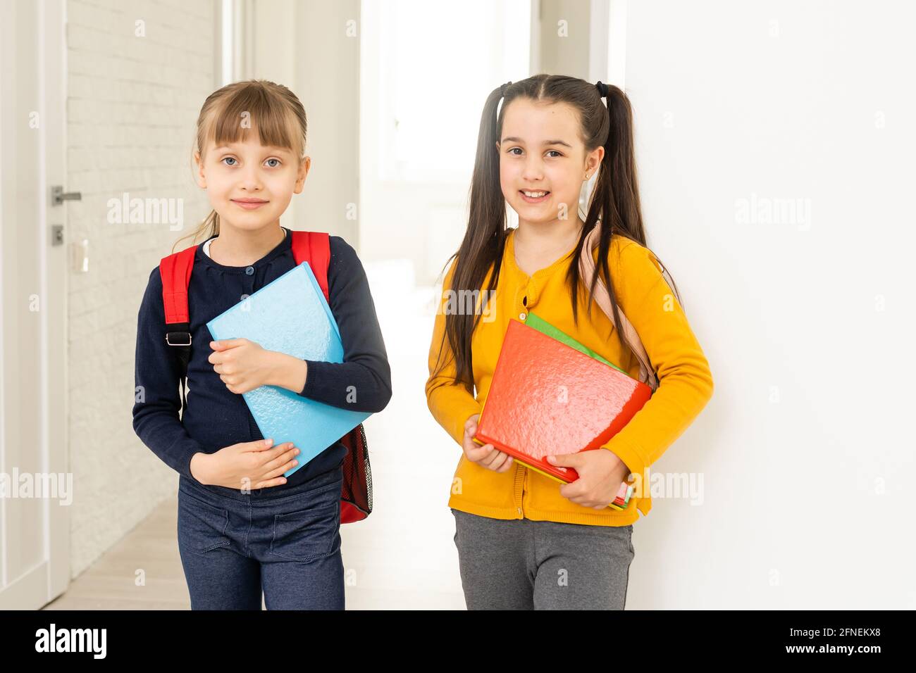 elementary school girls walking in classroom building Stock Photo - Alamy