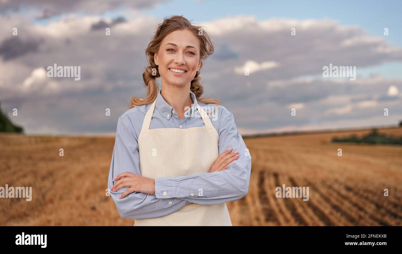 Woman farmer apron standing farmland smiling Female agronomist ...