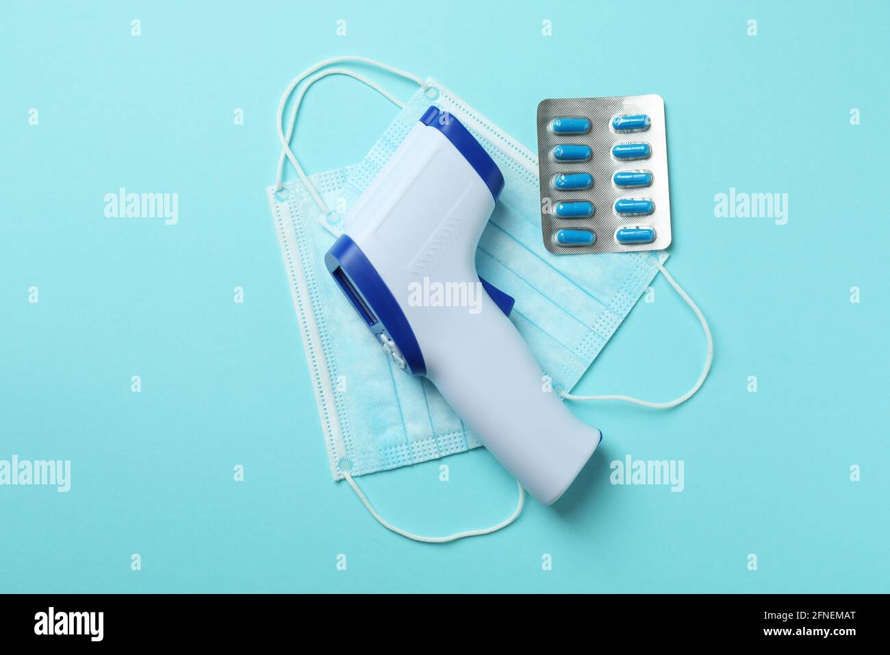 Medical tools and thermometer gun on blue background Stock Photo - Alamy