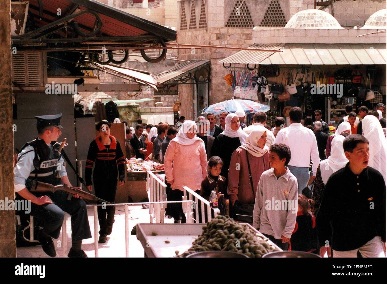 An Israeli police officer watches passersby in a street in the Old City ...