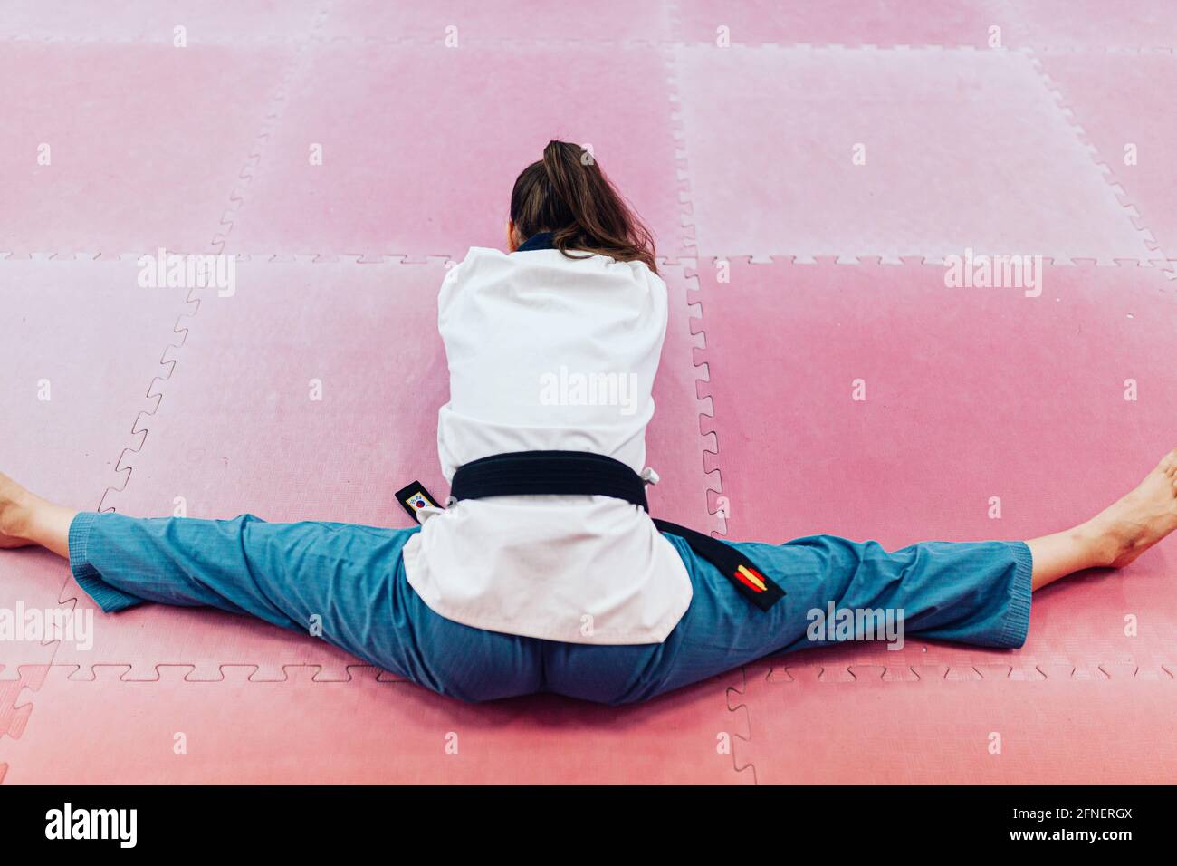 Young woman stretching in a dojo wearing taekwondo dobok Stock Photo ...