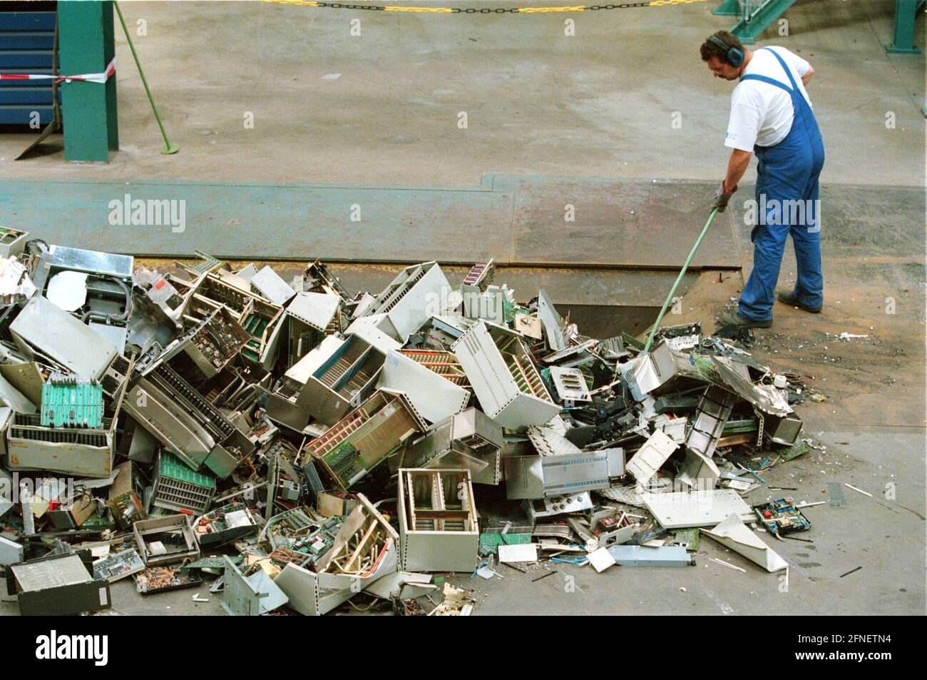 Worker sweeps circuit boards and other electronic waste onto an ...