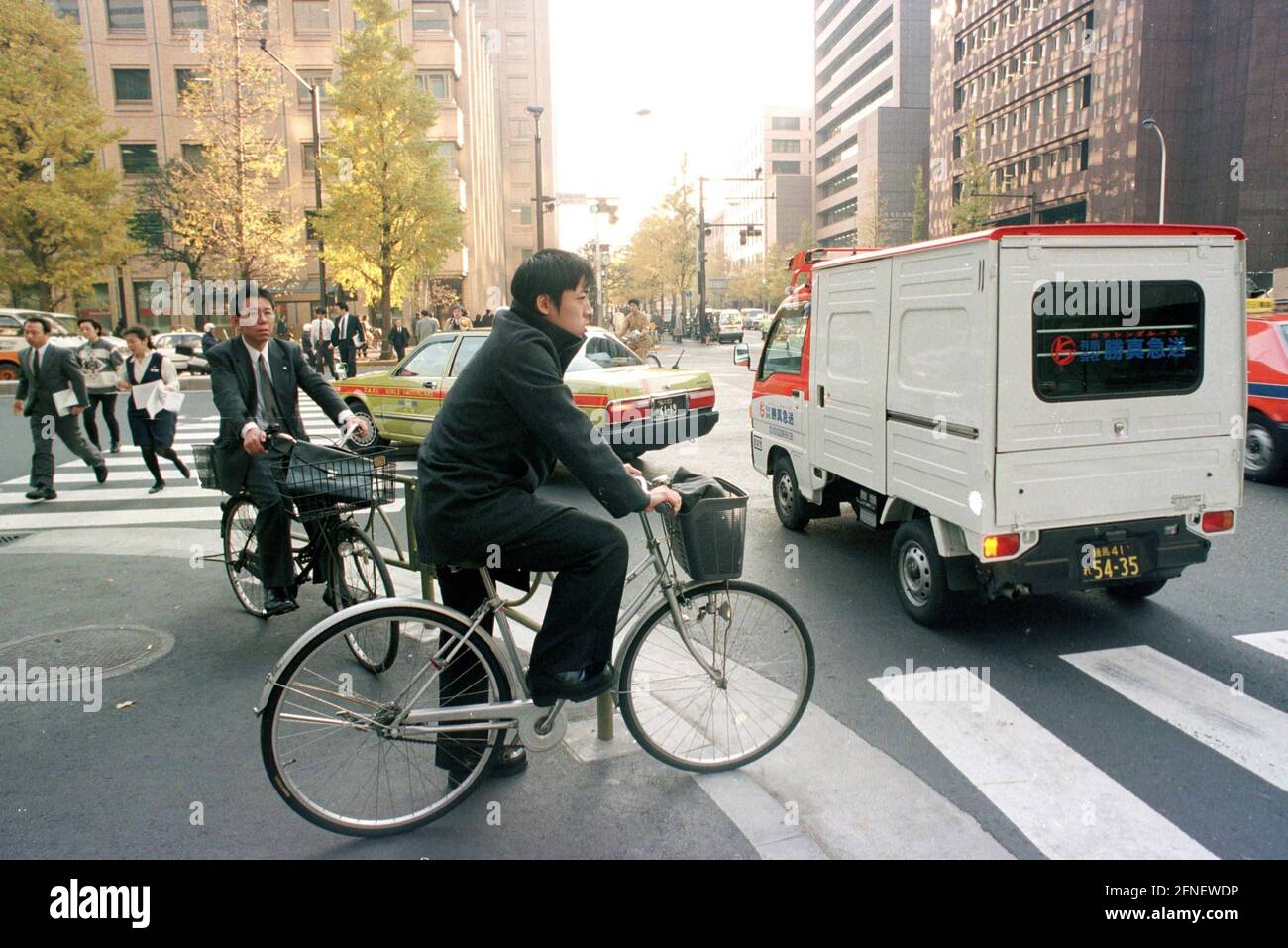 Bank messengers ride bicycles in Tokyo's banking district. [automated ...