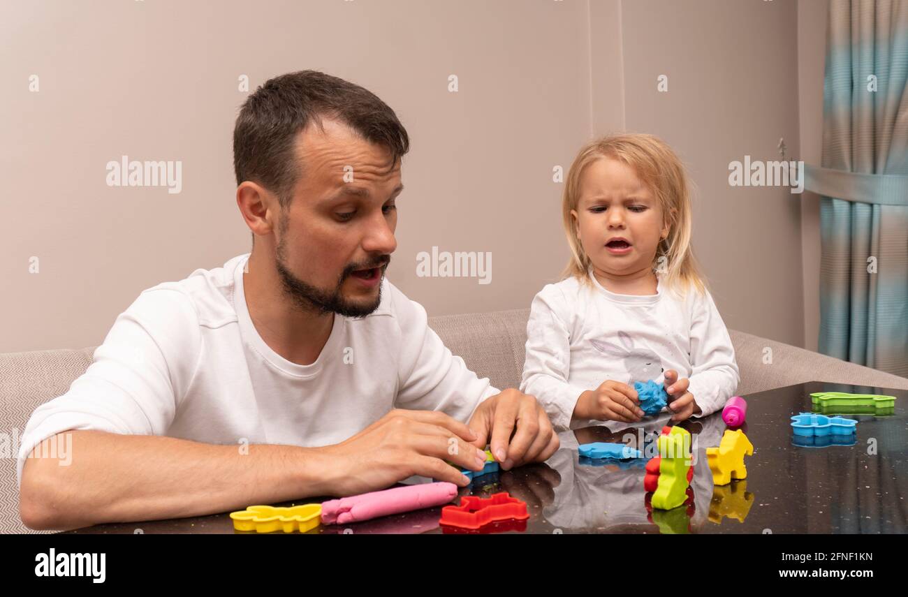 Crying child and young father playing with colorful play dough Stock ...