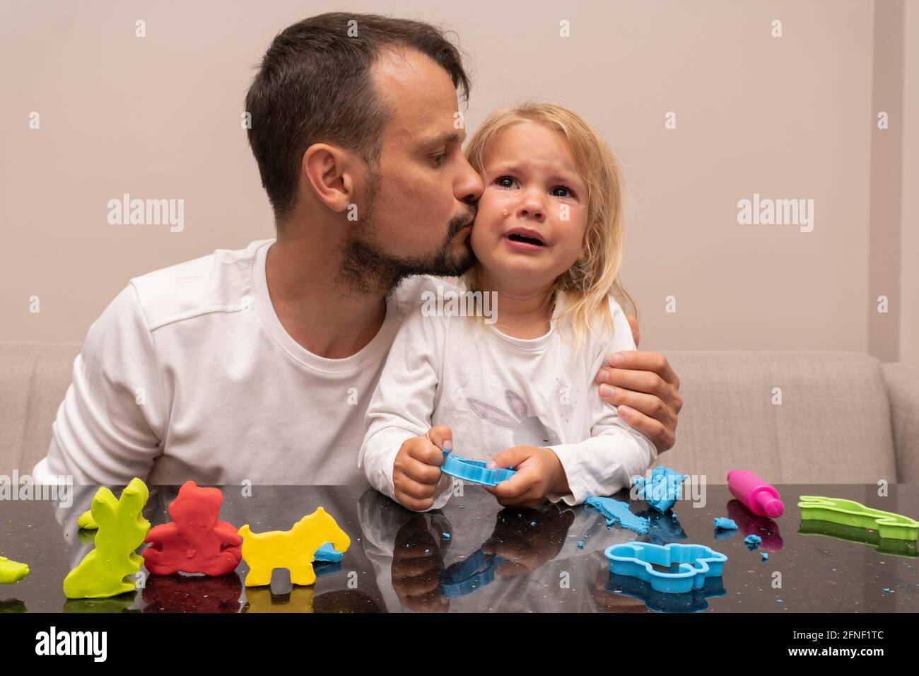 Young caucasian dad embraces and kisses his crying sad child Stock ...
