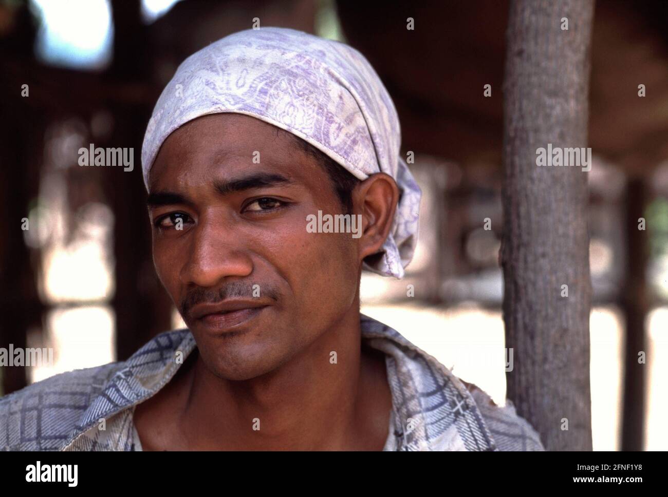Portrait of a man in a village on the south coast of East Timor ...