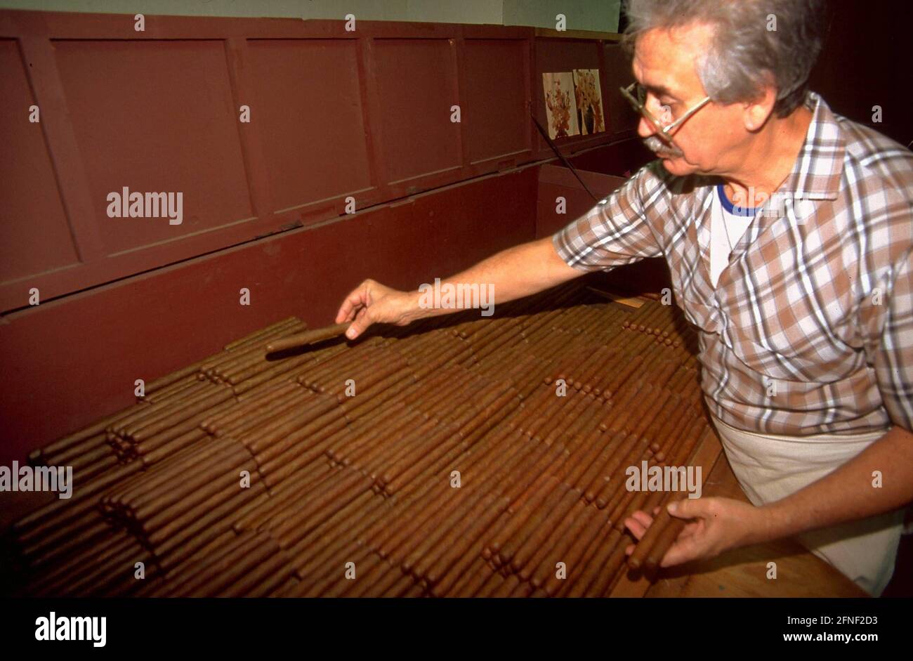 A worker at the Partagas cigar factory layers cigars. [automated ...