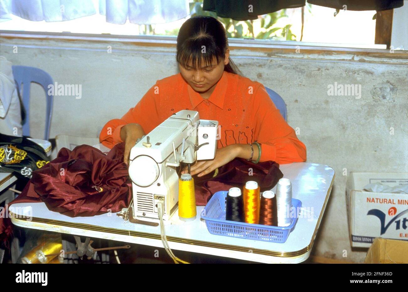 Vietnamese woman at the sewing machine in a workshop for the disabled ...