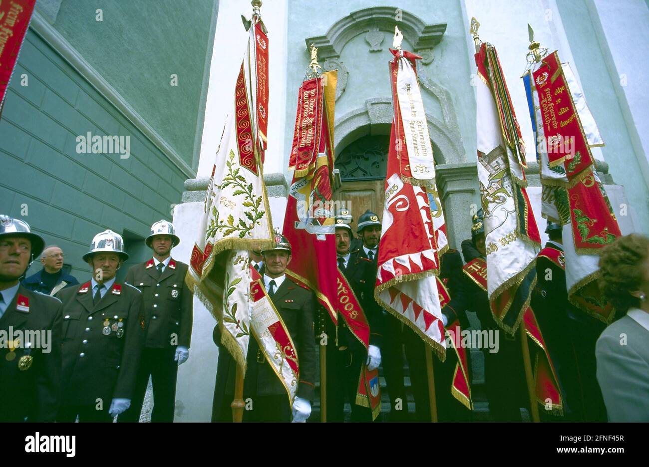 The Toblach fire brigade company in uniform with helmet and flags ...