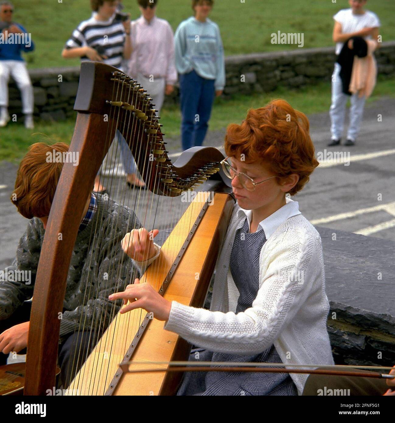 Irish folk music for tourists: An Irish girl at the harp. [automated ...