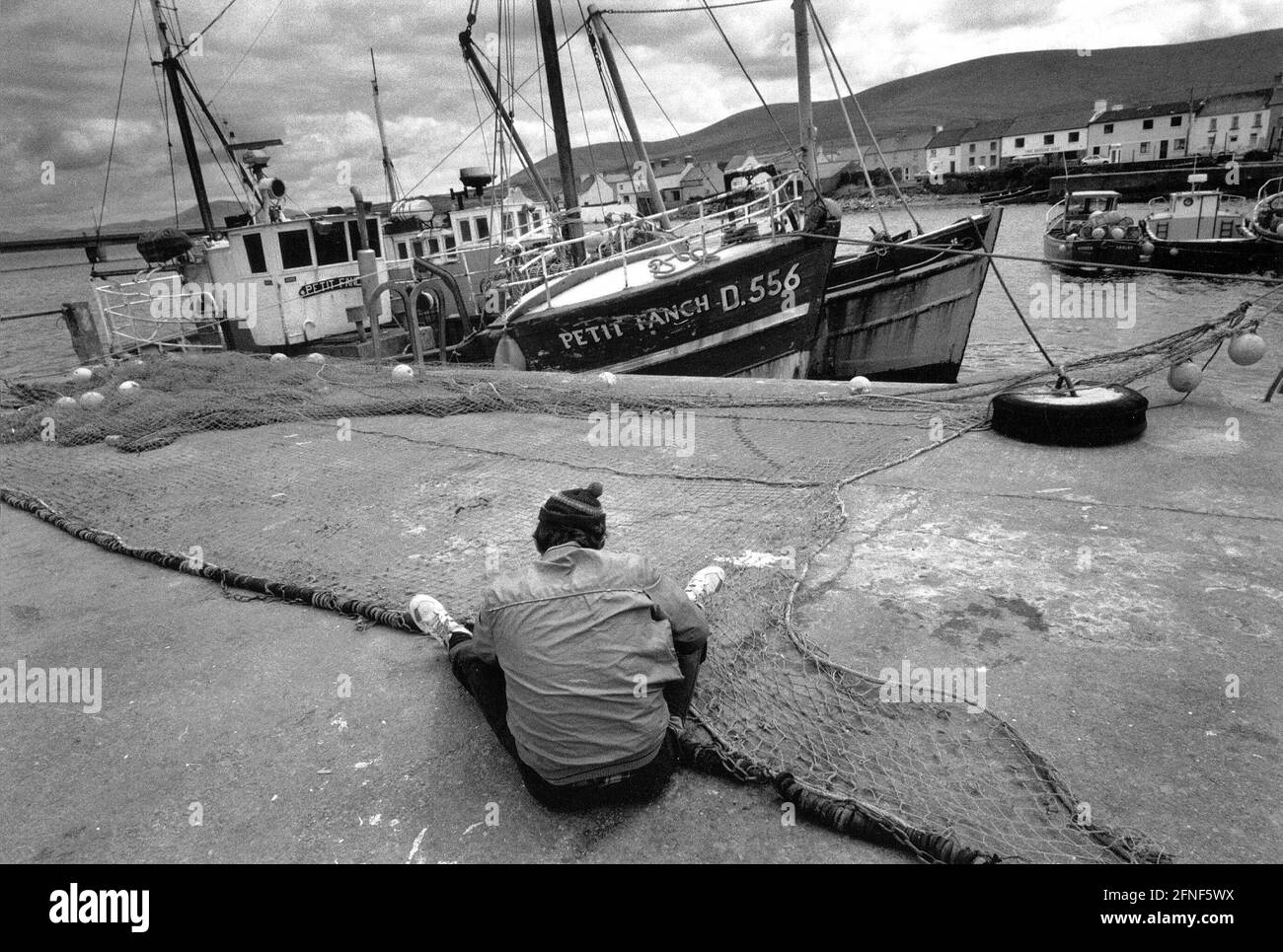 Irish fisherman in the harbour mending nets. [automated translation ...