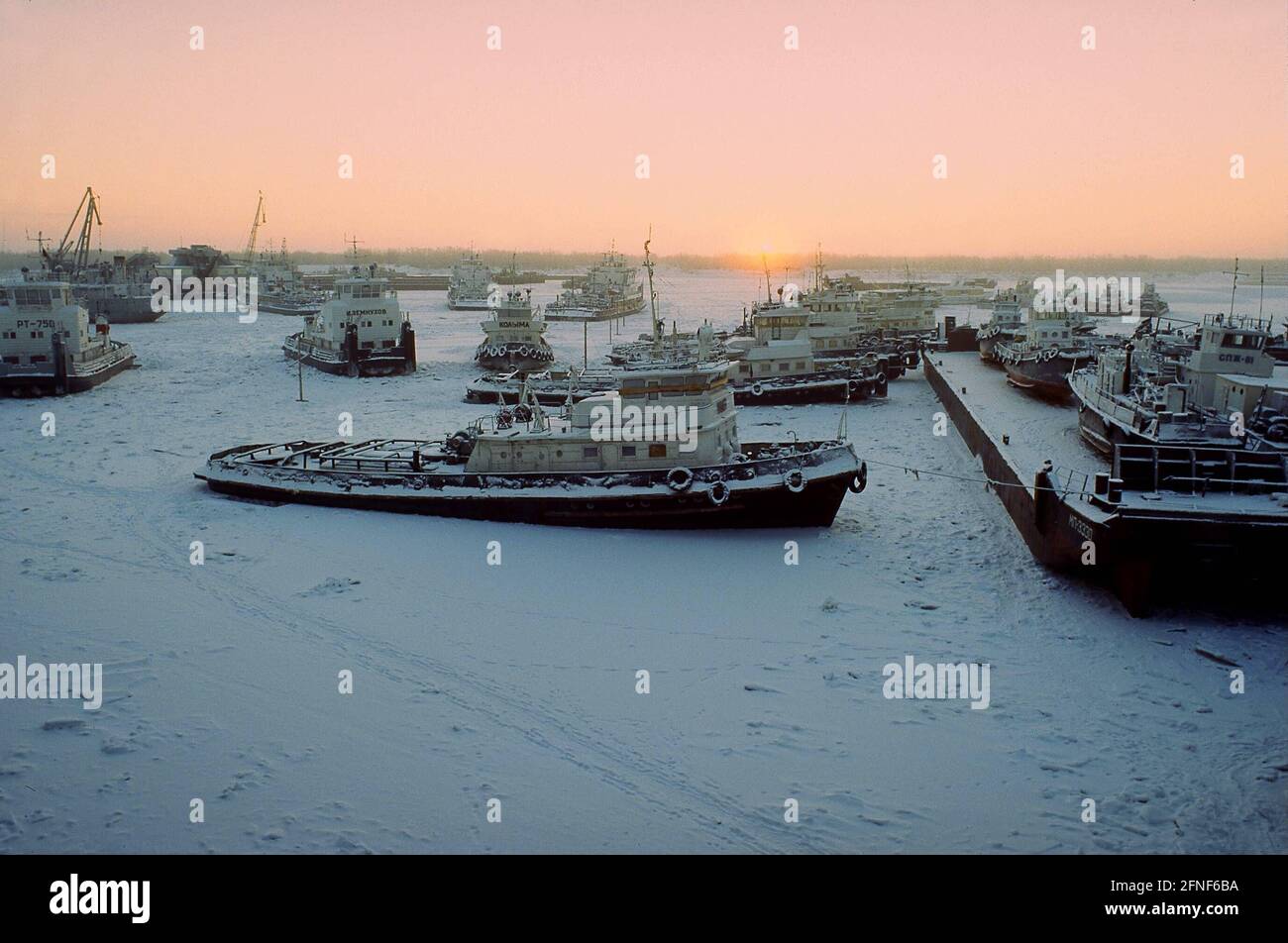 Frozen ships in the Lena port of Yakutsk at sunset. [automated ...