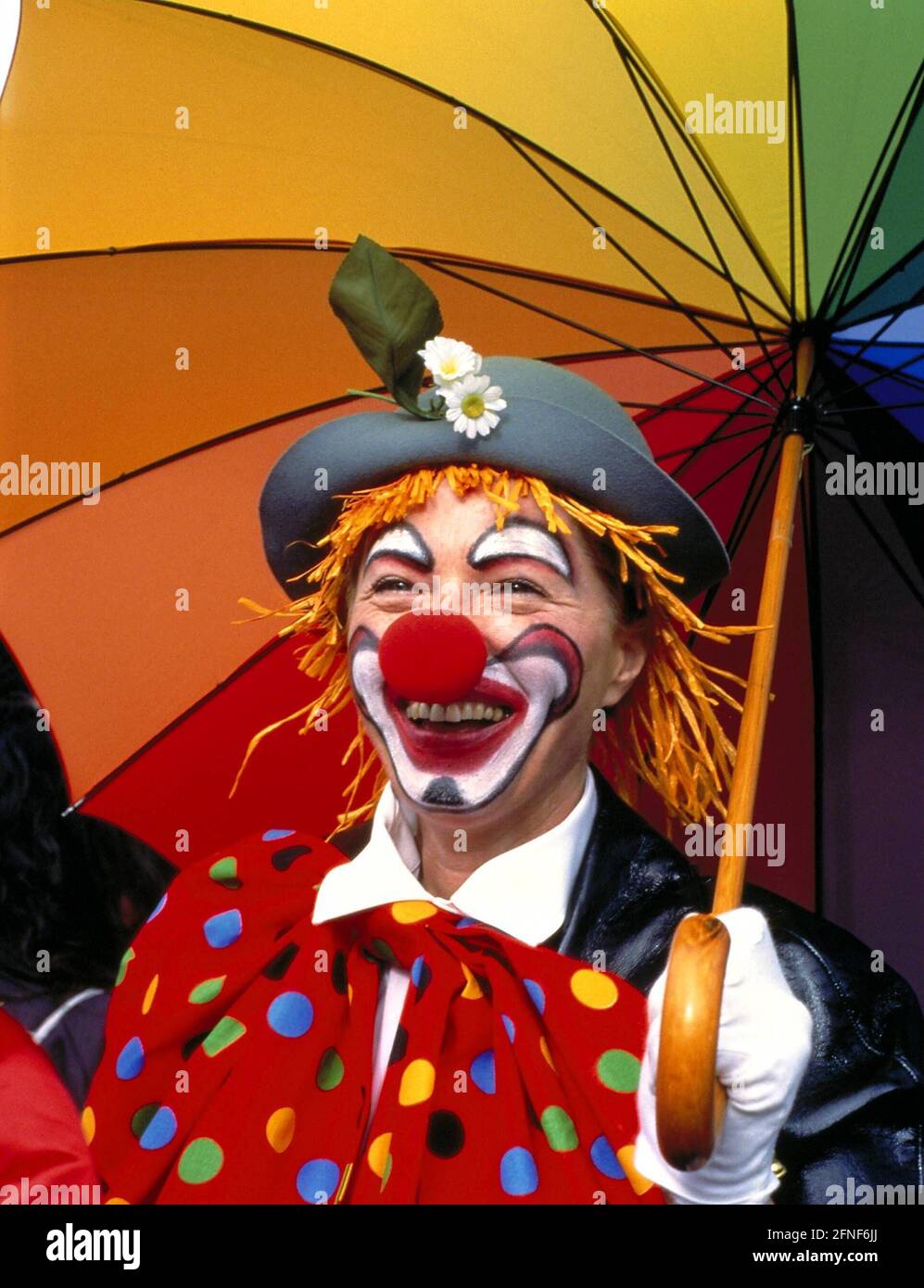 Laughing clown with rainbow-coloured umbrella at the Viktualienmarkt ...